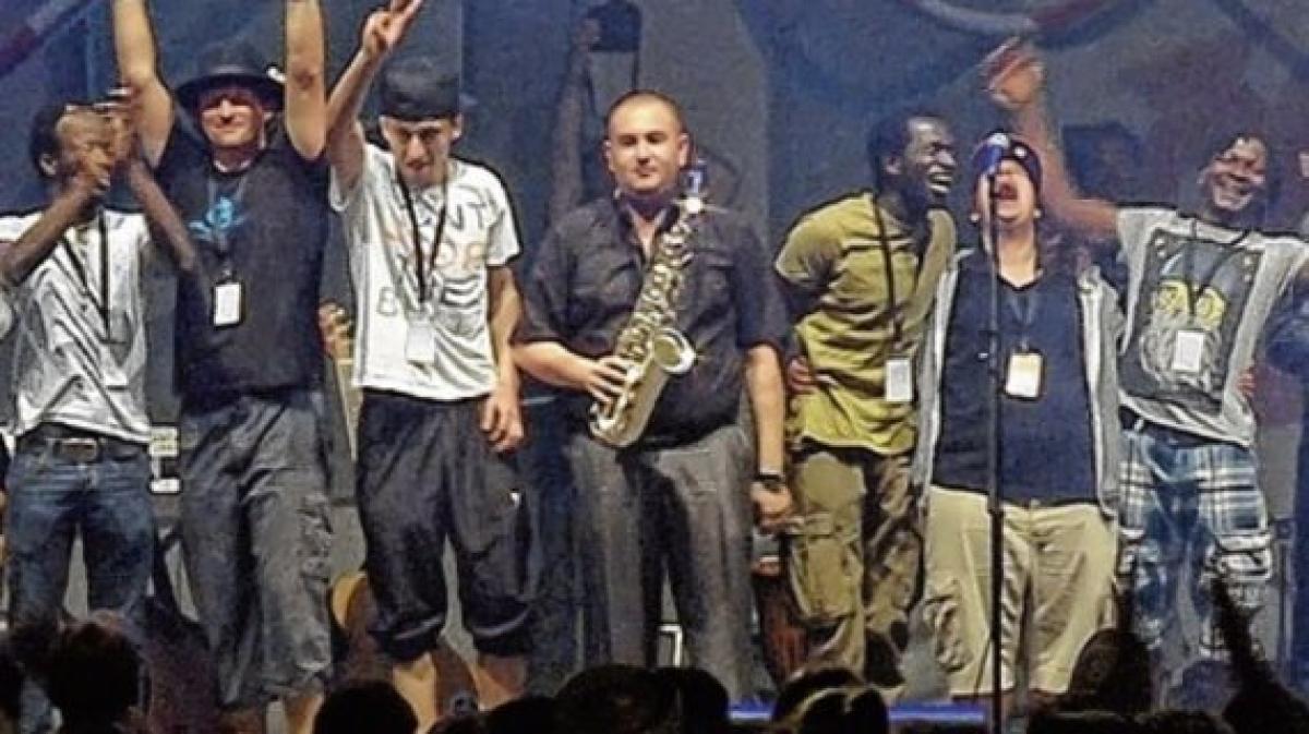 Flüchtlinge stehen als Musiker auf der Bühne