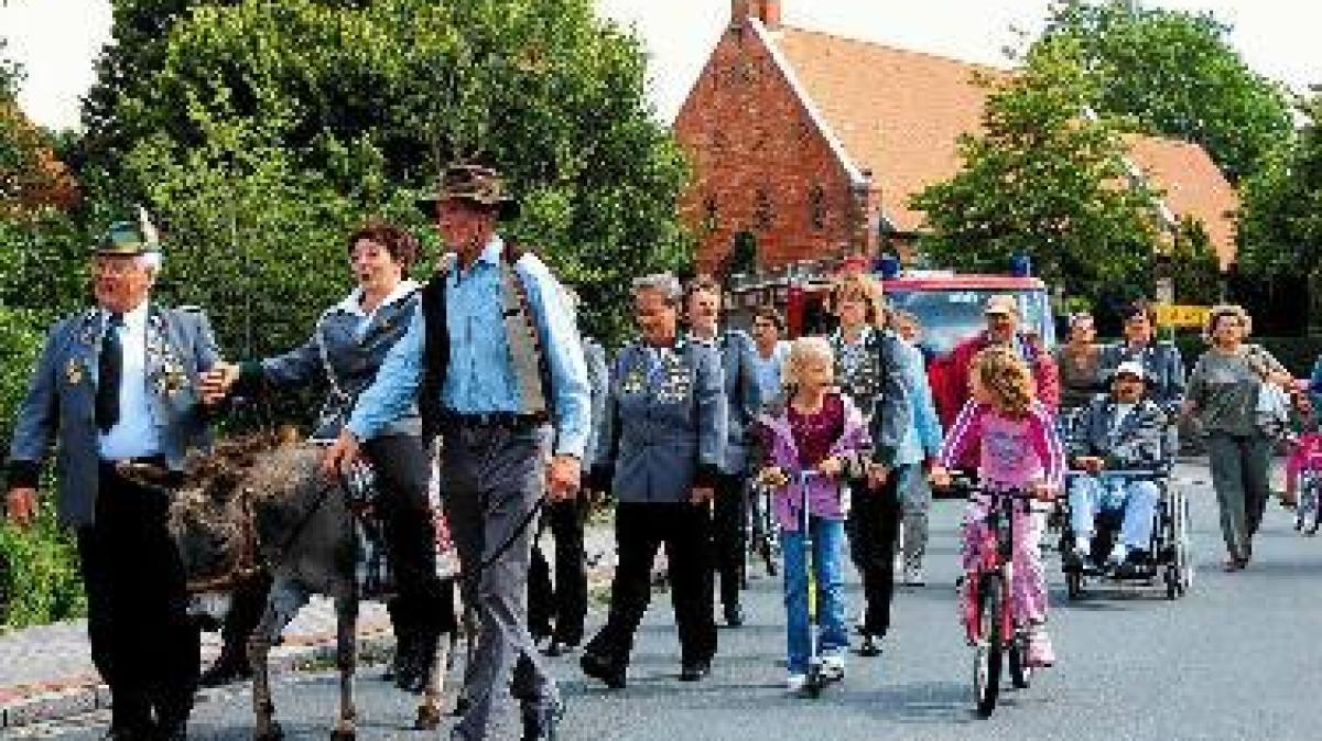 Mit dem Esel durch das Dorf geritten