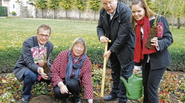 Bischof pflanzt Blumen zugunsten armer