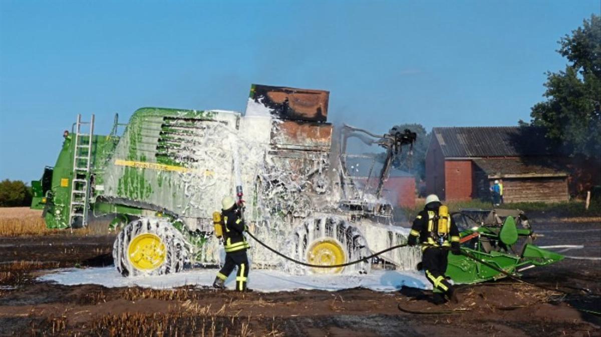 Feuerwehr löscht Mähdrescher und Kornfeld in