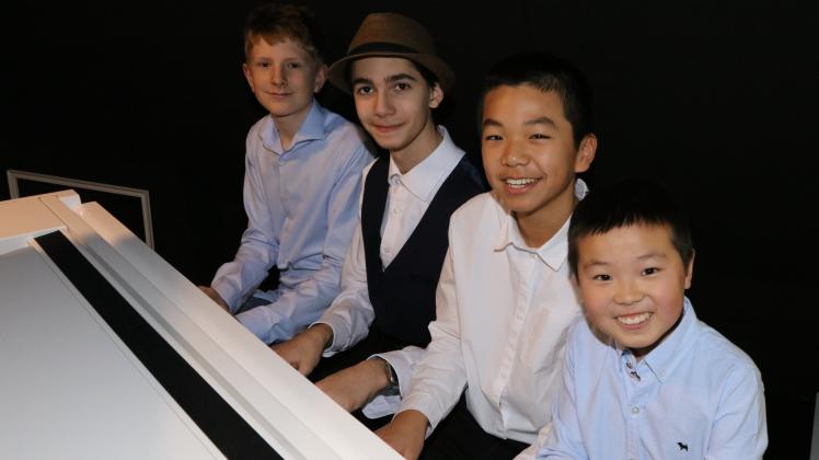 Vier Pinneberger spielen mit acht Händen ein Klavier